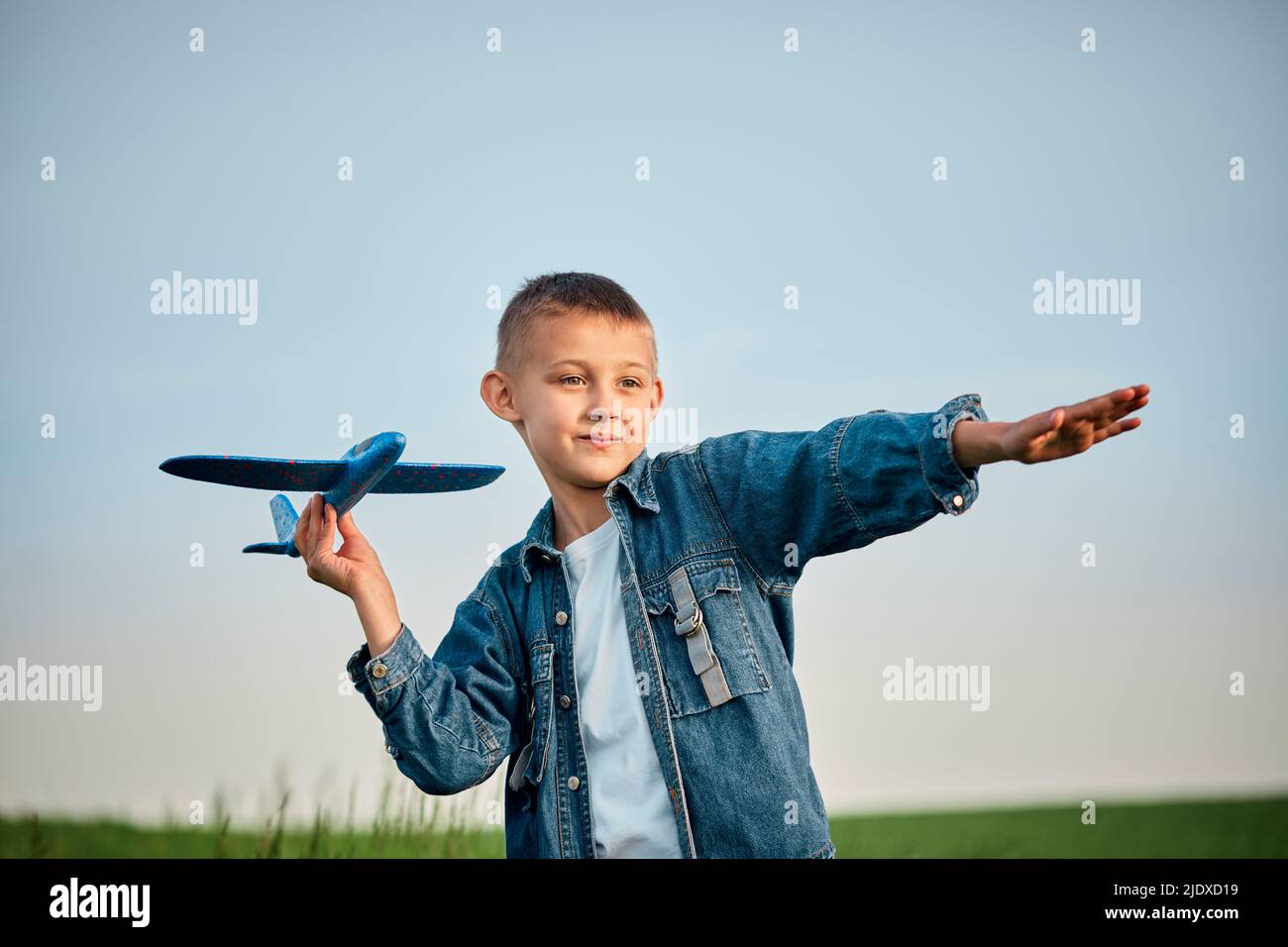 Boy standing and holding toy airplane hi-res stock photography and ...