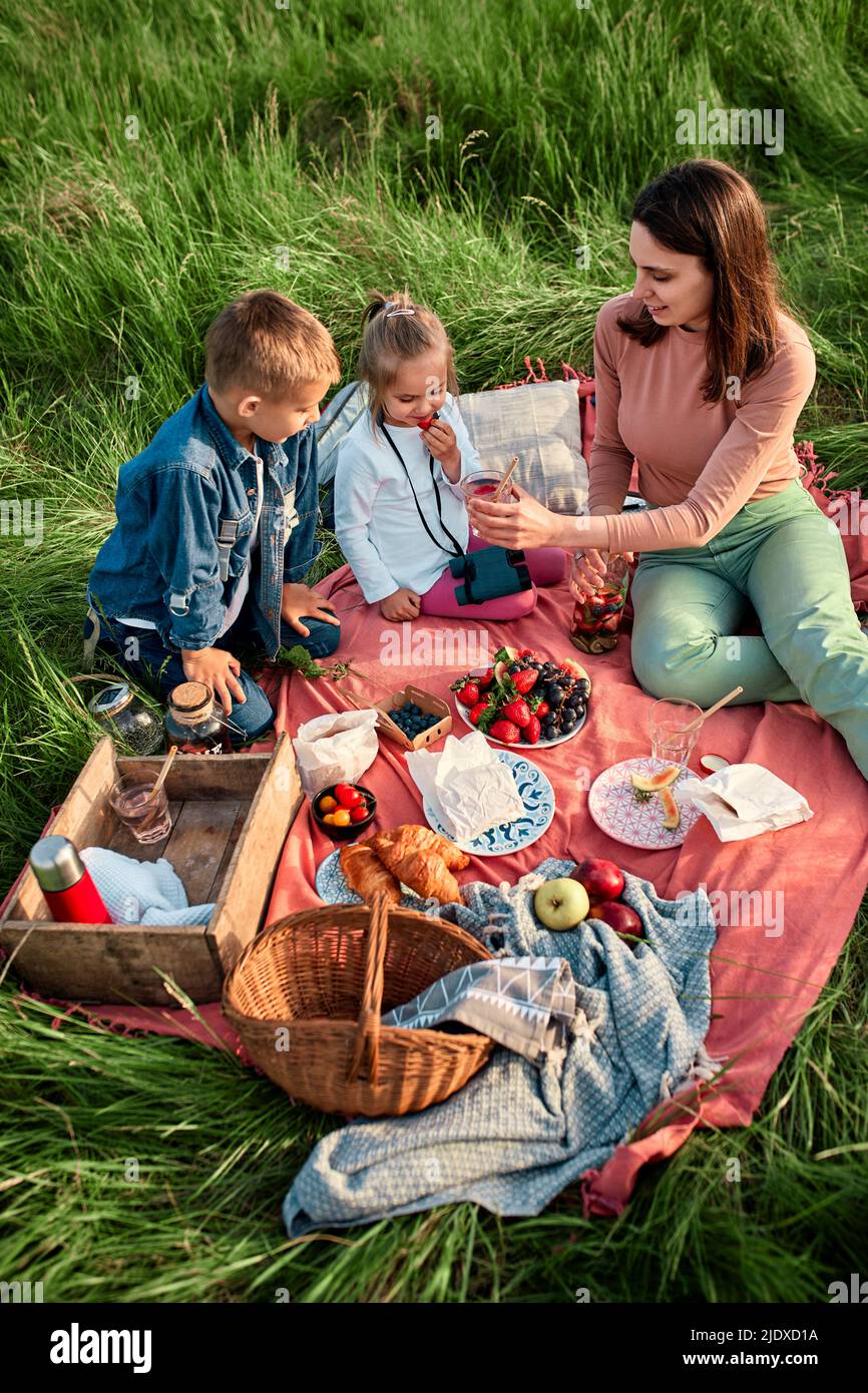 Mother giving food two children hi-res stock photography and images - Alamy