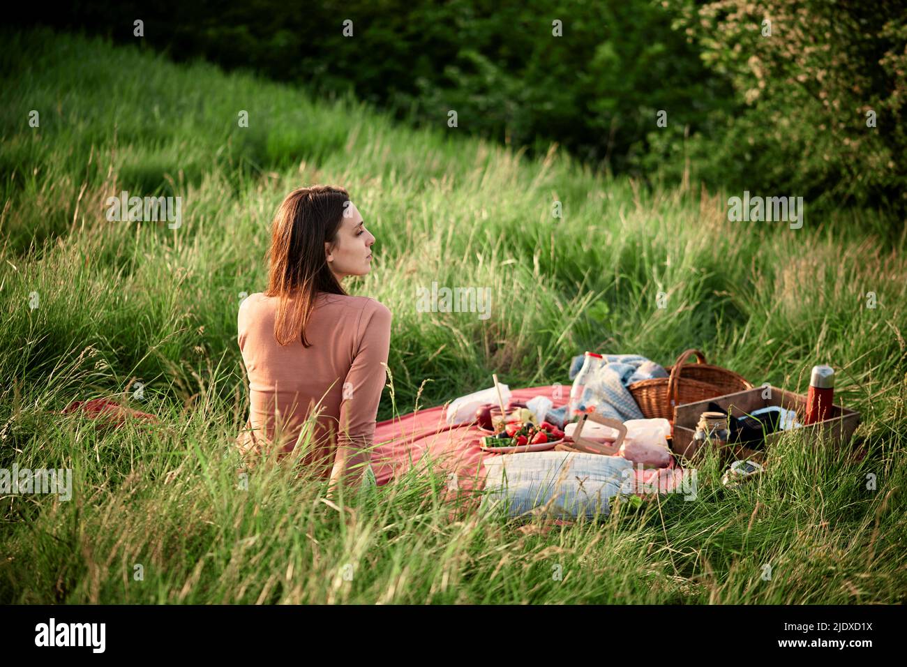 Contemplative woman sitting in field on weekend Stock Photo - Alamy