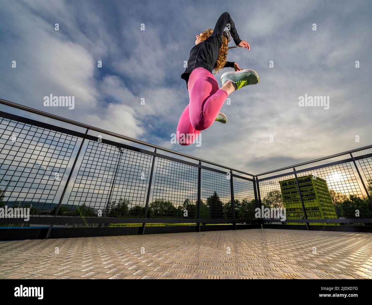 Young woman jumping fence hi-res stock photography and images - Alamy