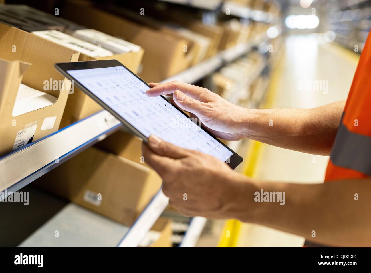 Worker checking list through tablet PC in warehouse Stock Photo - Alamy