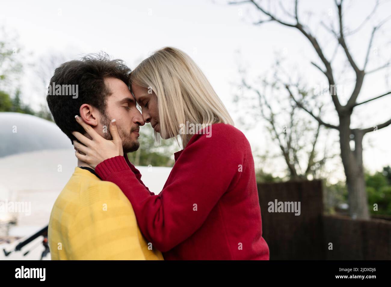 Affectionate couple with eyes closed touching foreheads with each other ...