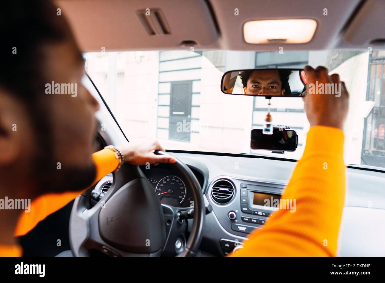Man looking in rear-view mirror of car Stock Photo - Alamy
