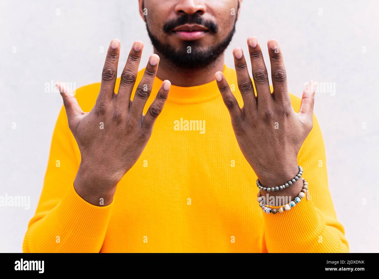 Man showing hands in front of white wall Stock Photo - Alamy