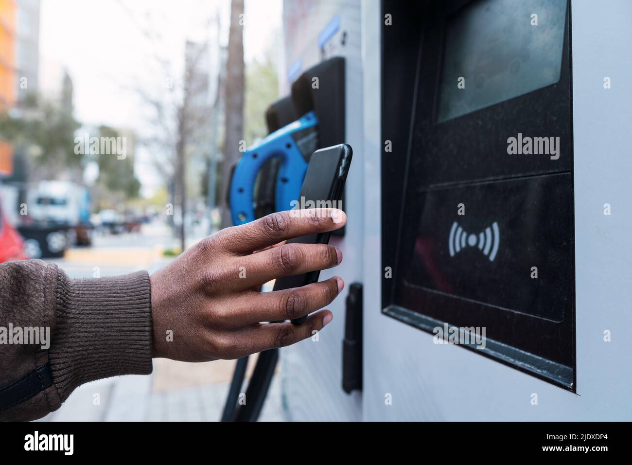 Hand of man paying through smart phone at charging station Stock Photo ...