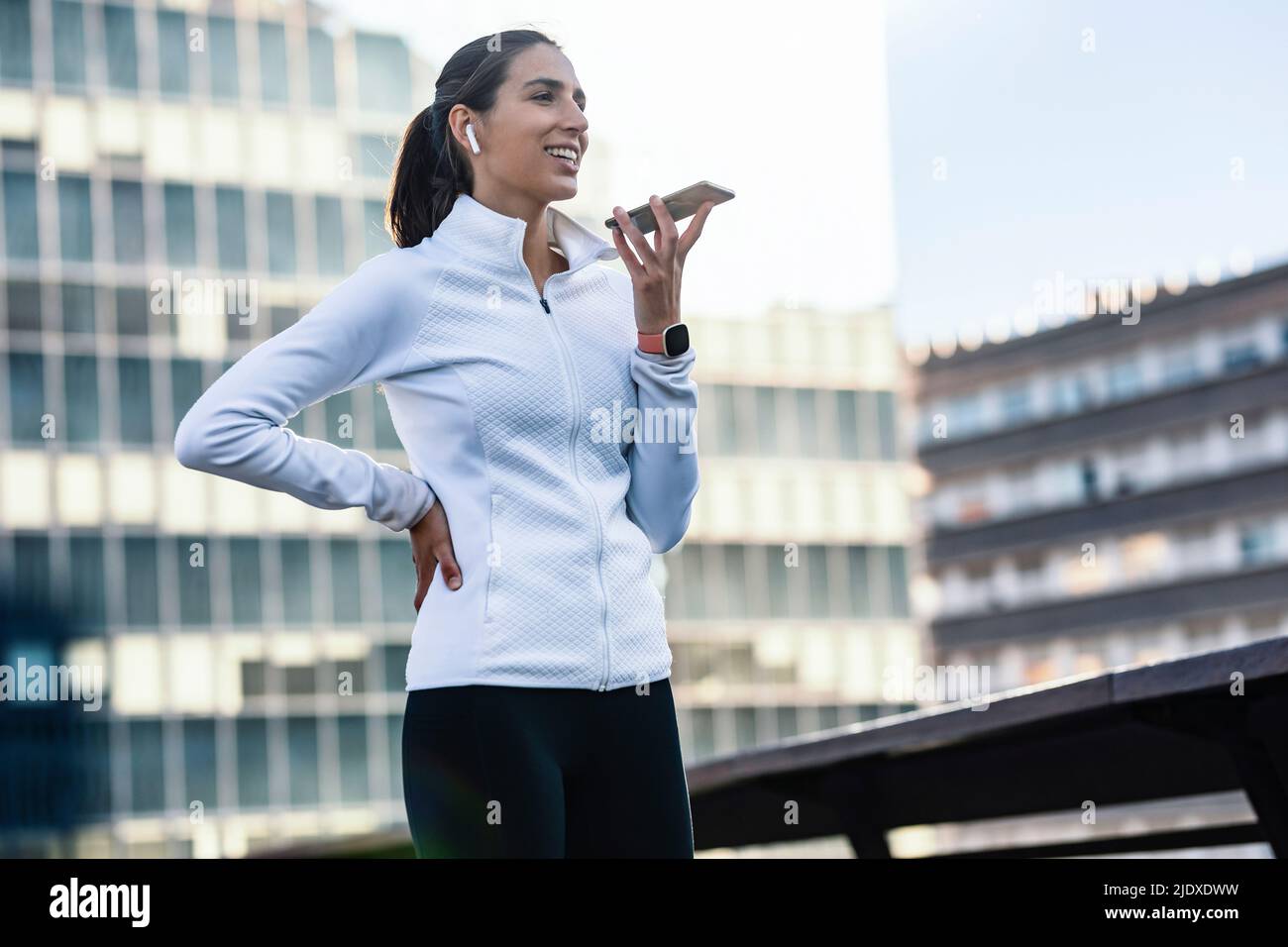 Woman holding phone ear building hi-res stock photography and images ...