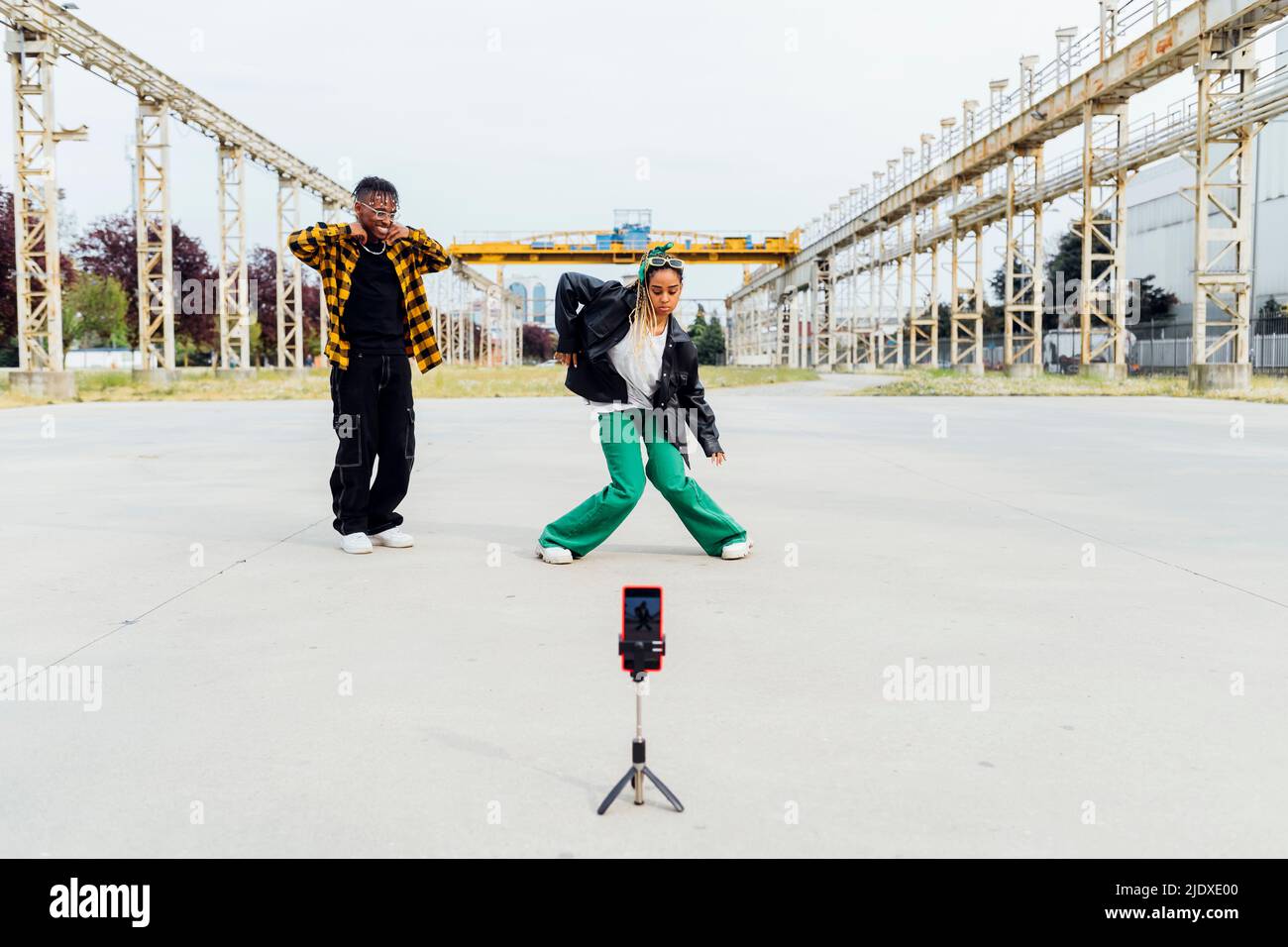 Young woman filming dance video through smart phone on footpath Stock ...