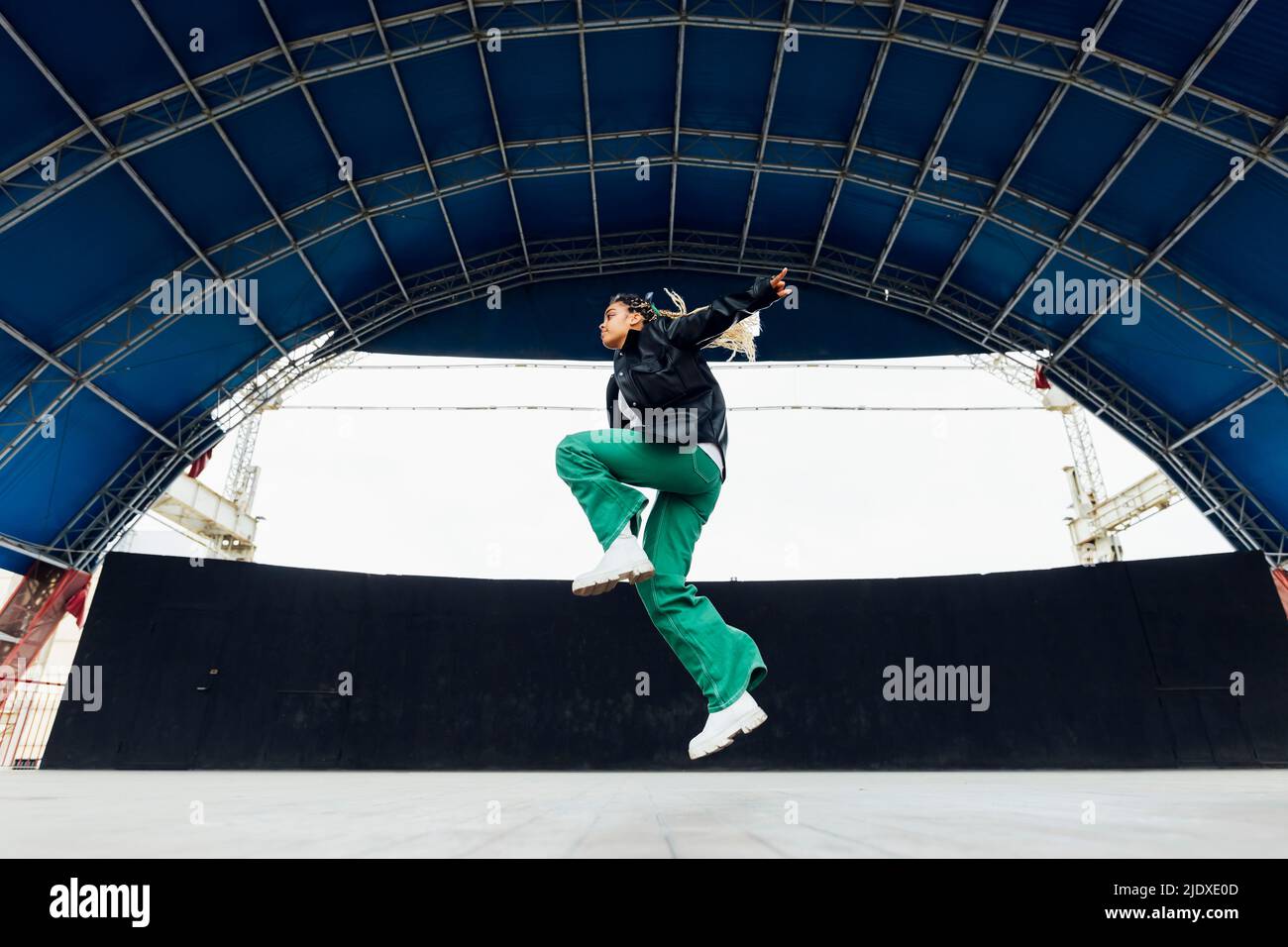 Happy young woman jumping under ceiling Stock Photo - Alamy