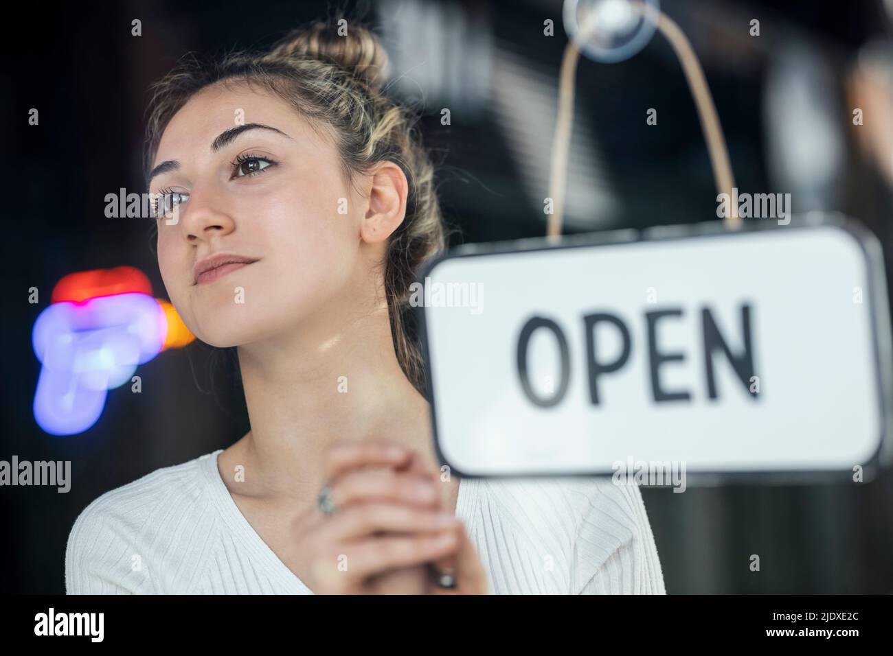 Thoughtful restaurant owner by open sign seen through glass Stock Photo ...