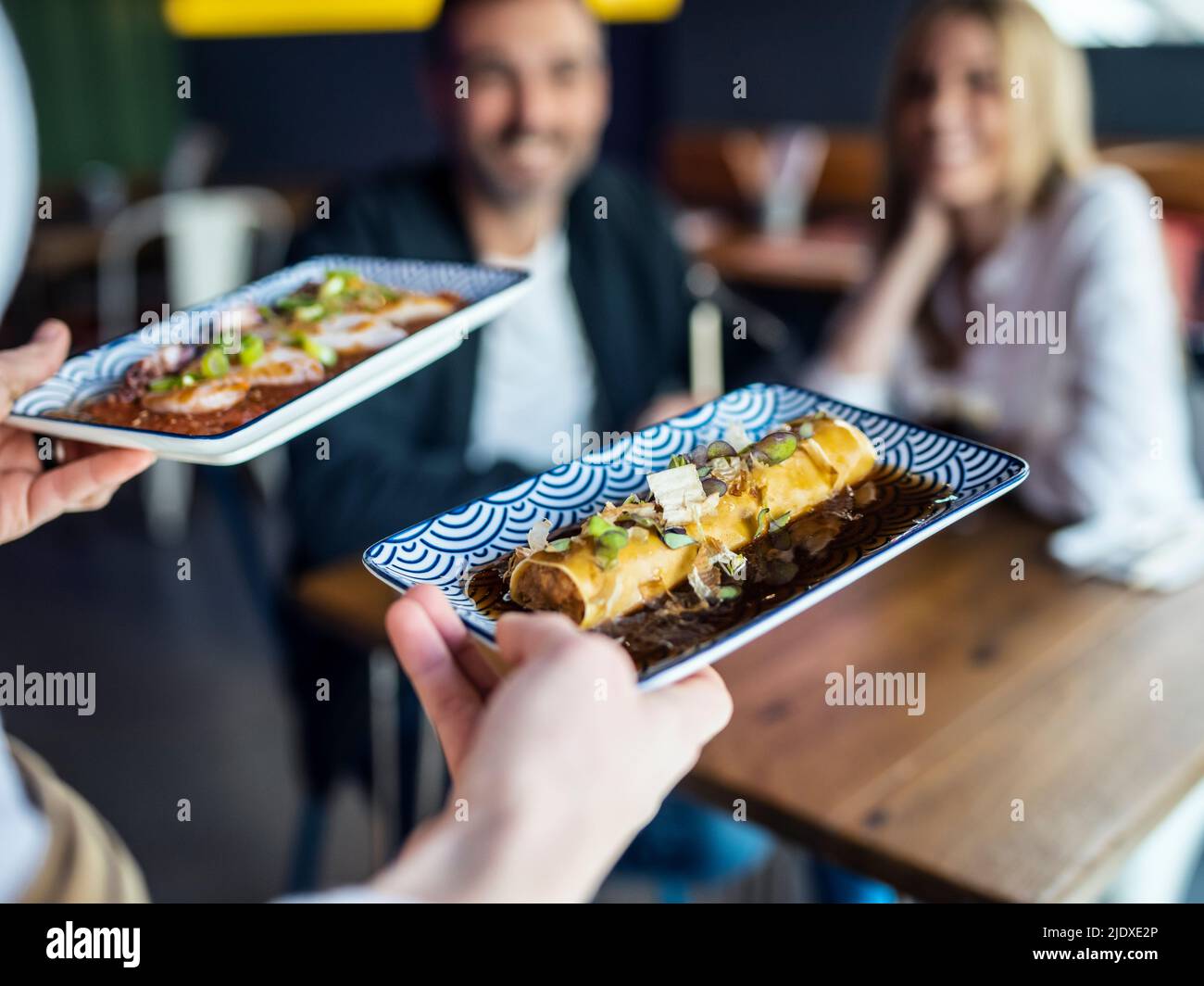 Hands of waitress serving food to customers Stock Photo - Alamy