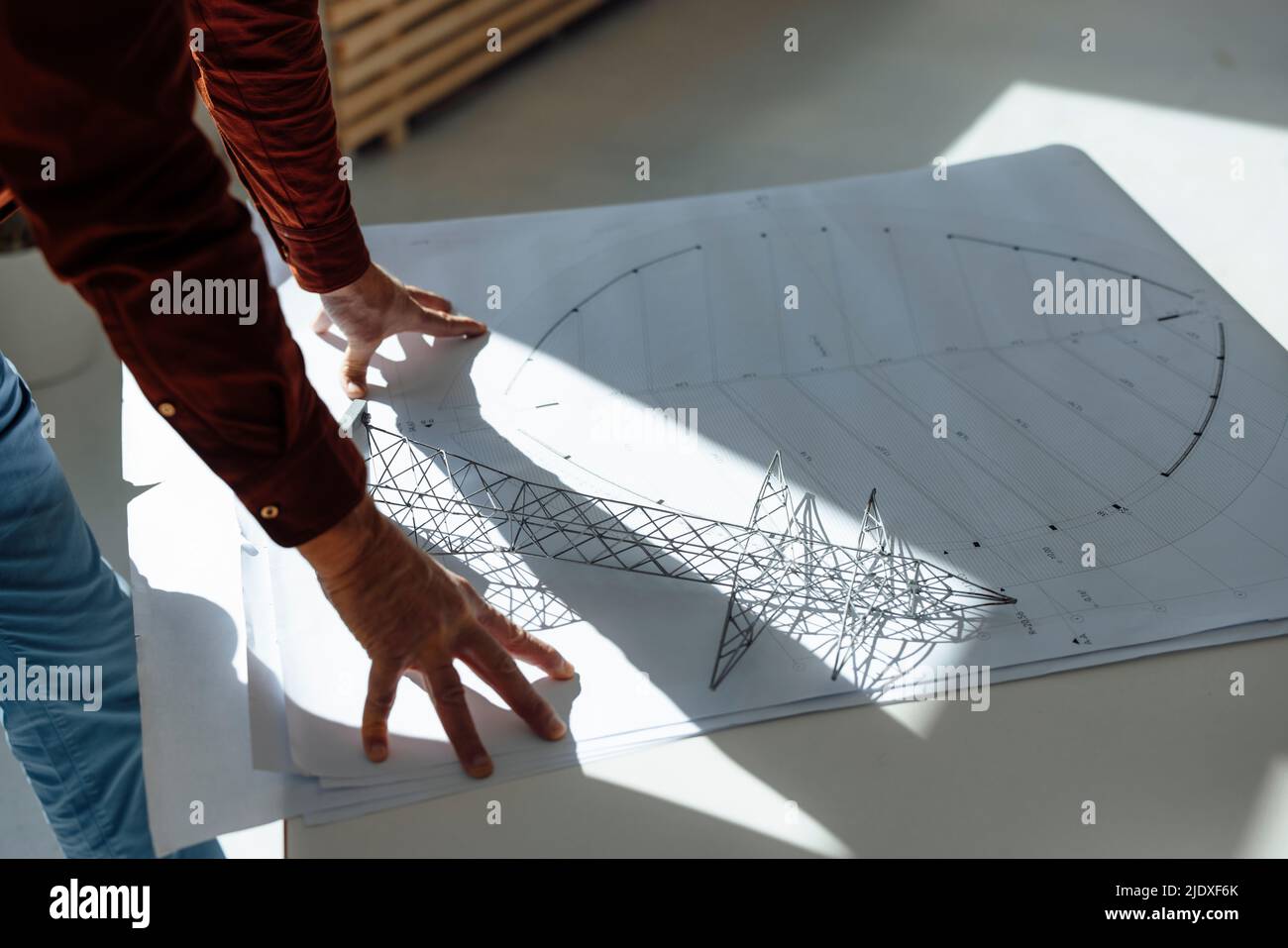 Hands of businessman by electric pylon model on blueprint at desk Stock ...