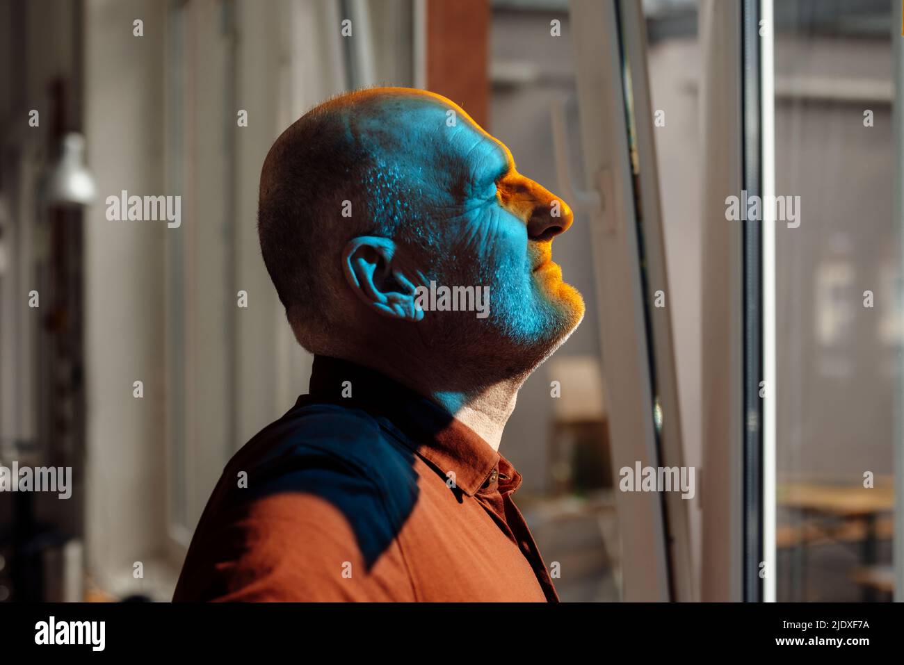 Businessman with blue light on face at office Stock Photo - Alamy