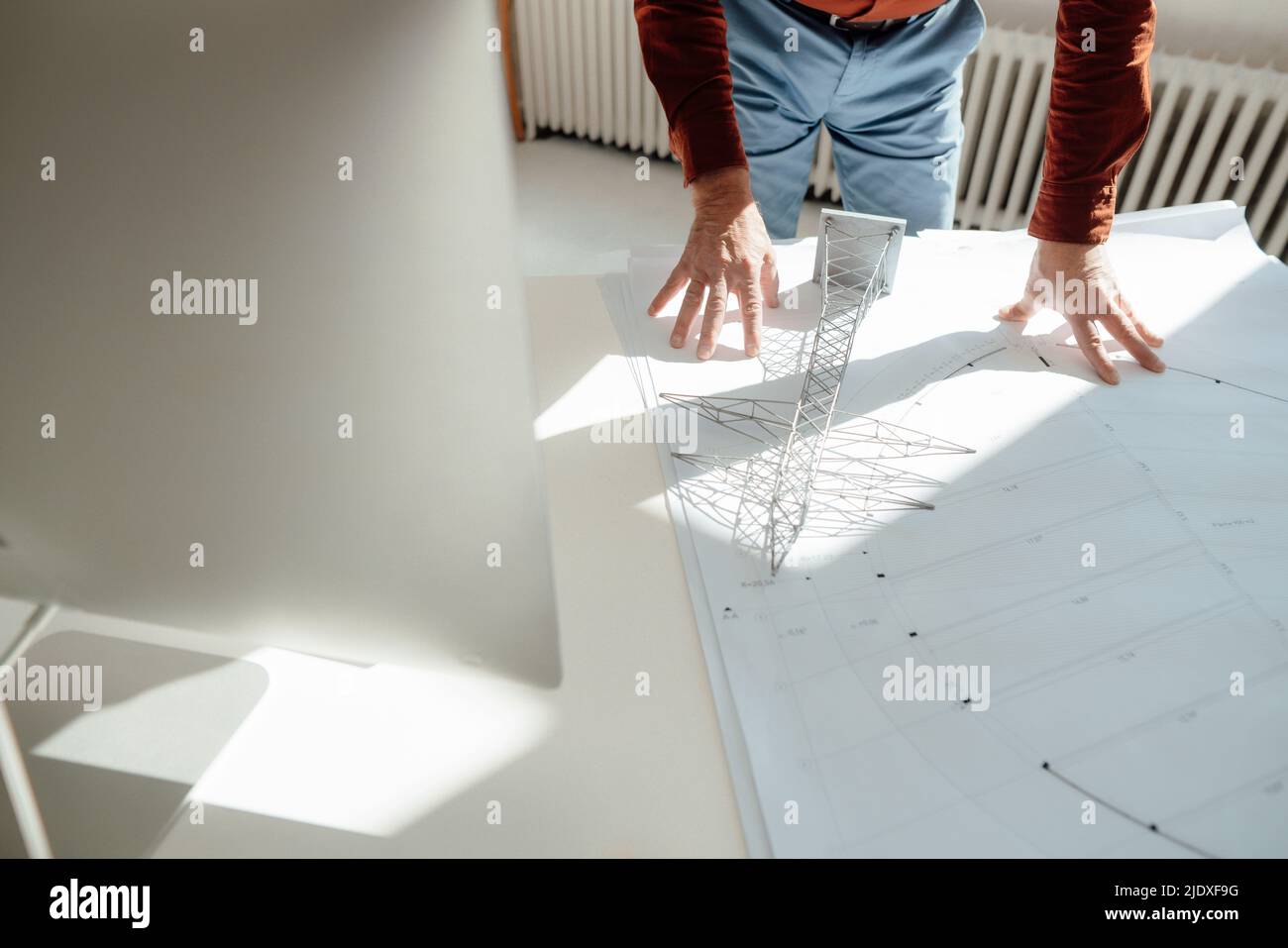 Hands of engineer by electricity pylon model on blueprint at desk Stock ...