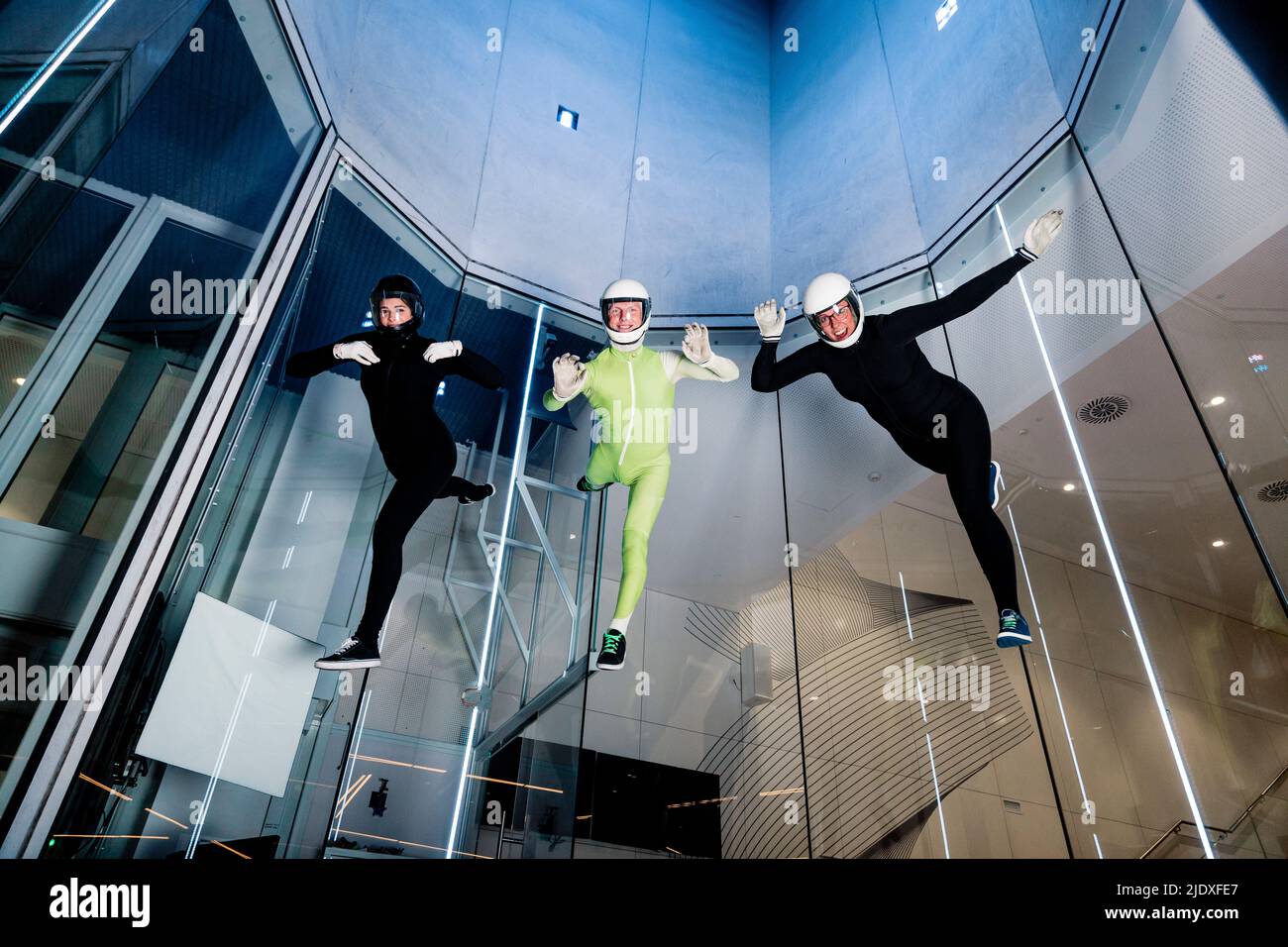 Smiling man with friends flying in wind tunnel Stock Photo - Alamy