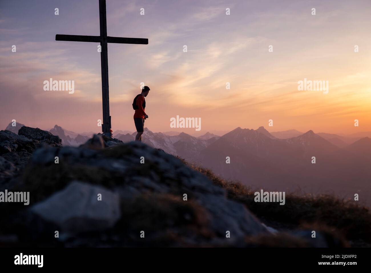 Hiker standing by summit cross on mountain Stock Photo - Alamy