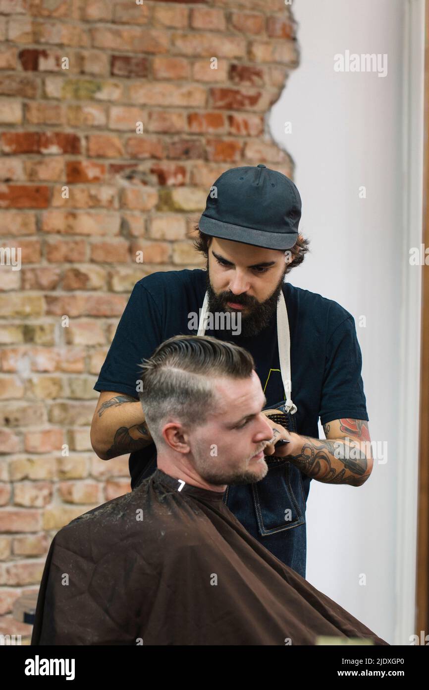Young man in barber shop having haircut Stock Photo - Alamy