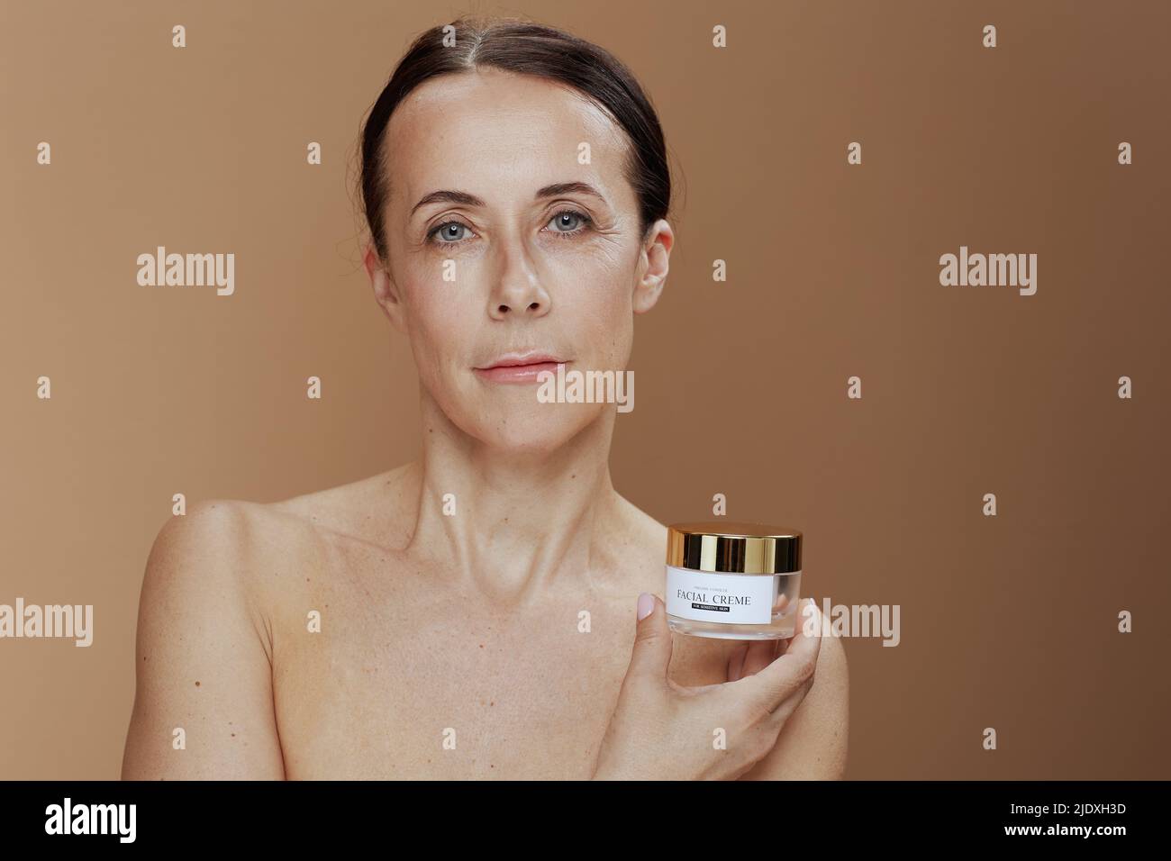 modern woman with facial cream jar isolated on beige background Stock ...