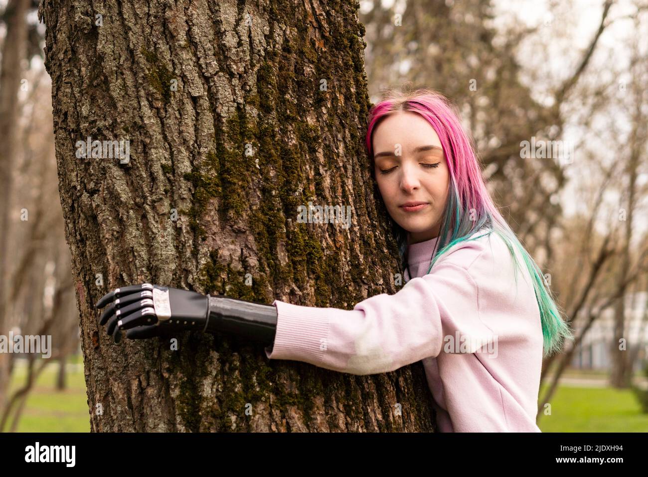 Woman with amputated hand embracing tree trunk Stock Photo - Alamy