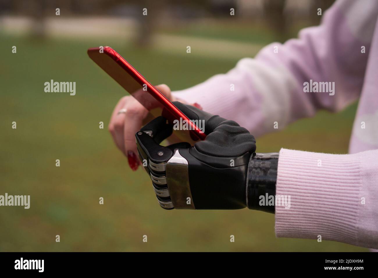Young woman holding smart phone with artificial limb Stock Photo - Alamy