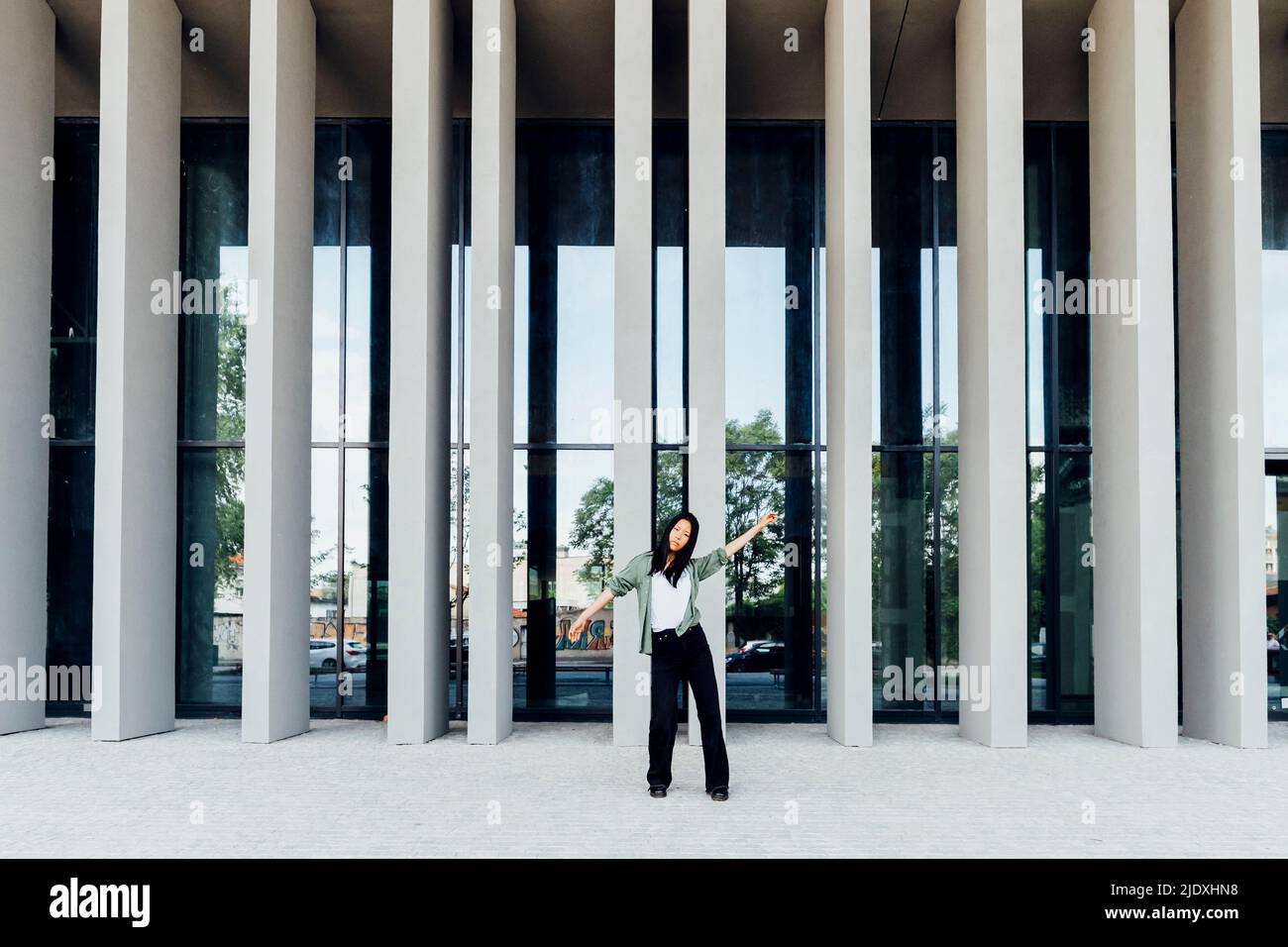 Young woman standing in front of columns Stock Photo - Alamy