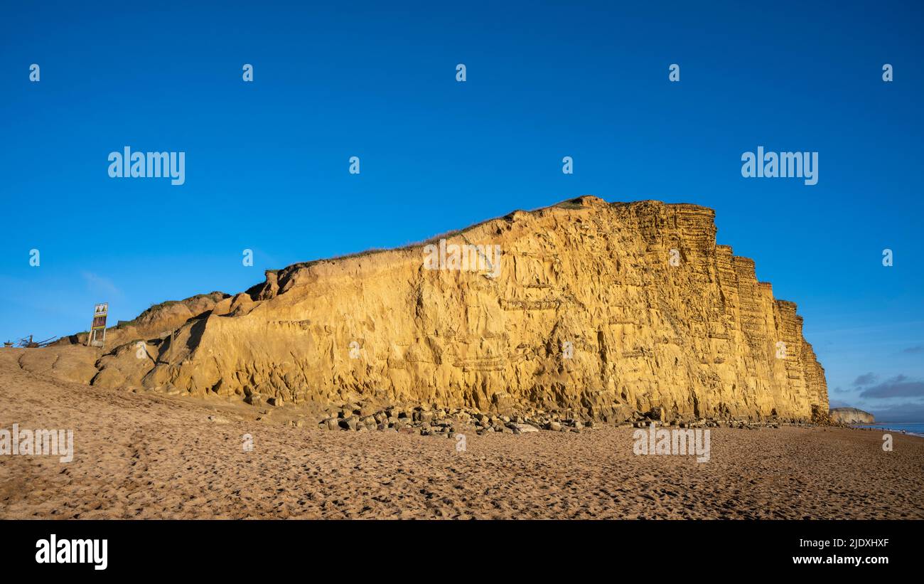 Sandy beach and sandstone cliff along jurassic coast hi-res stock ...