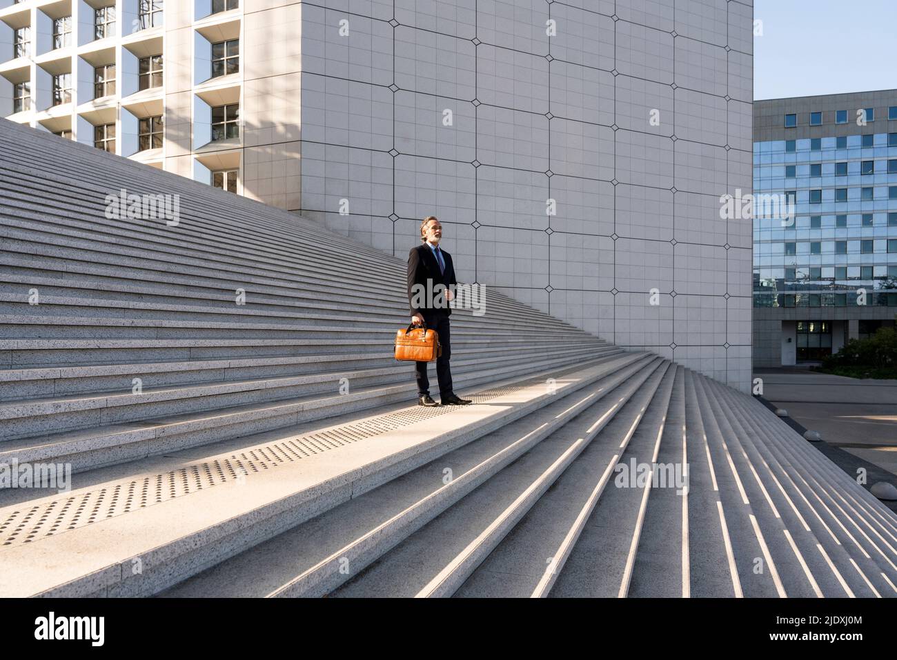 Standing looking away holding building exterior architecture hi-res ...