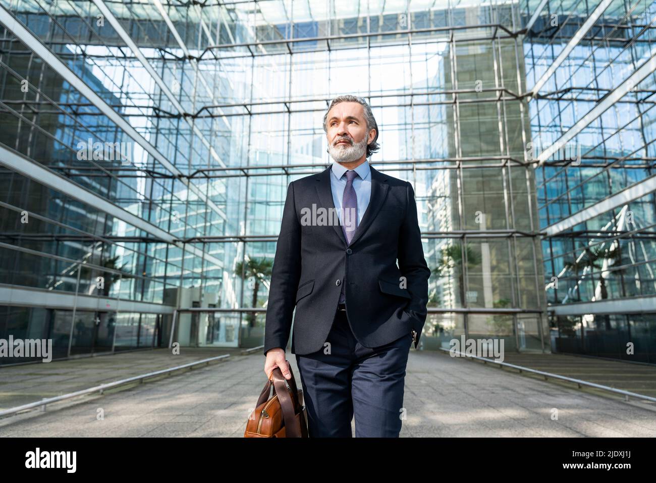 Walking building exterior architecture hands in pockets hi-res stock ...