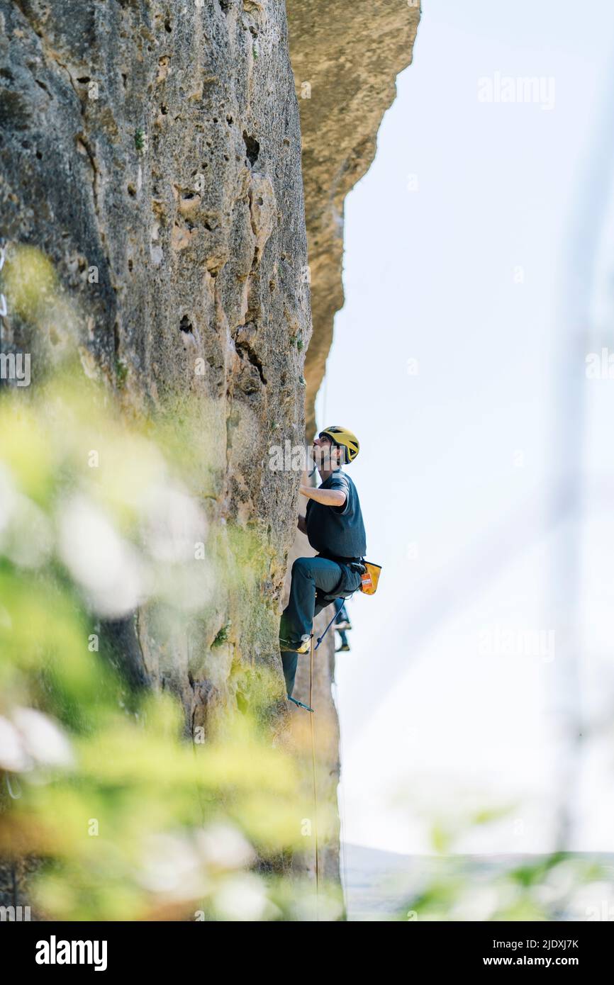Active man rock climbing on sunny day Stock Photo - Alamy