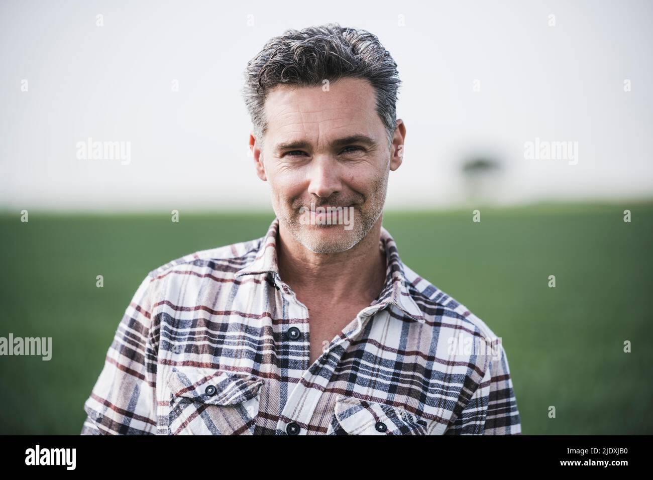 Smiling mature man wearing plaid shirt Stock Photo - Alamy