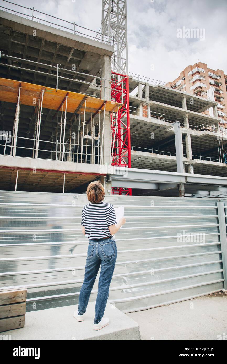 Architect looking at incomplete building under construction Stock Photo ...