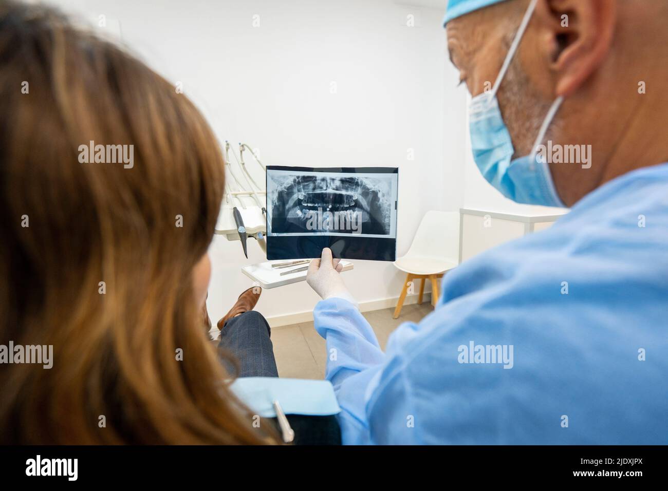 Dentist showing x-ray to patient at clinic Stock Photo - Alamy