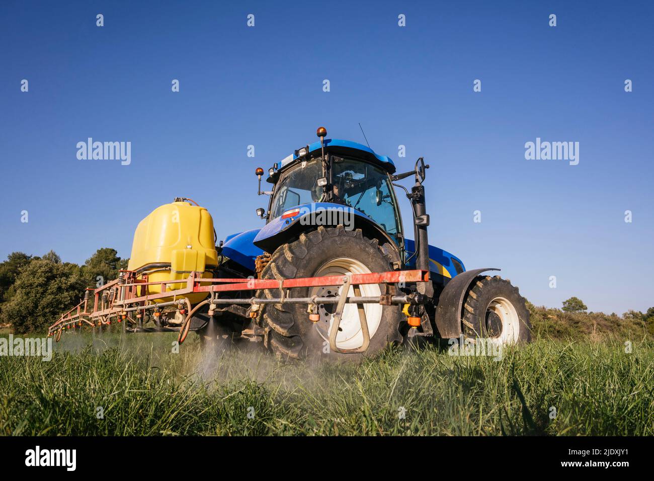 Crop sprayer spraying fertilizer on field Stock Photo - Alamy