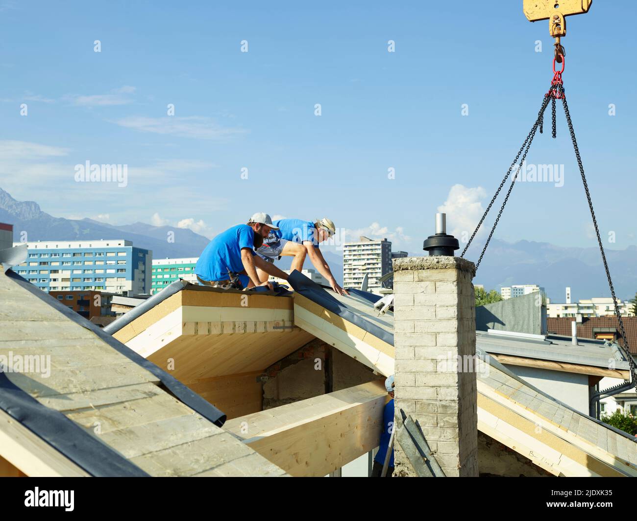 Workers at construction site working on rooftop Stock Photo - Alamy