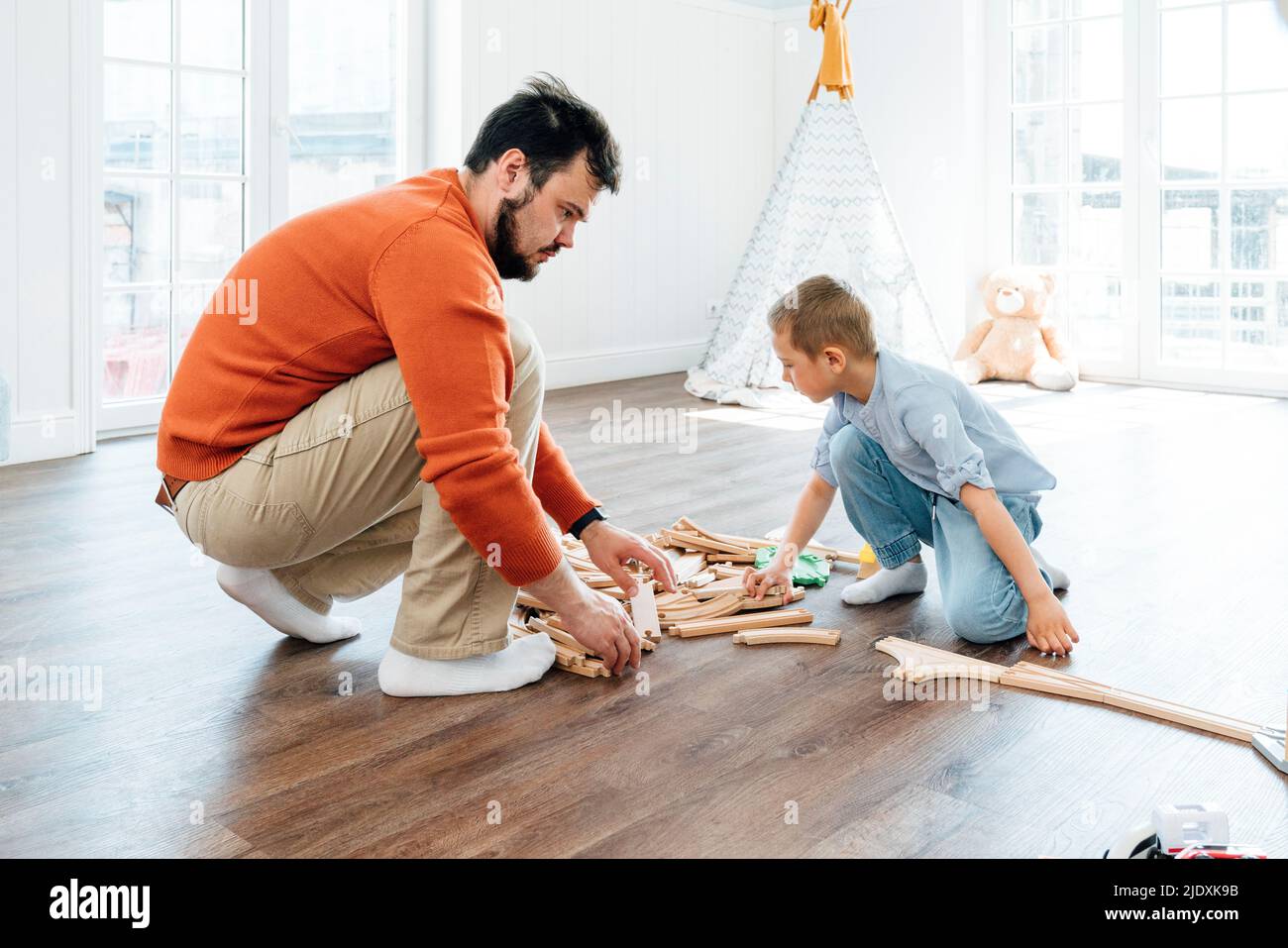 Father with son building toy railroad track at home Stock Photo - Alamy