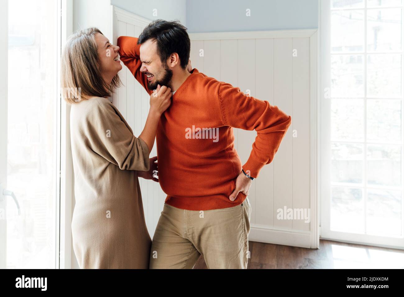 Cheerful couple standing together at home Stock Photo - Alamy