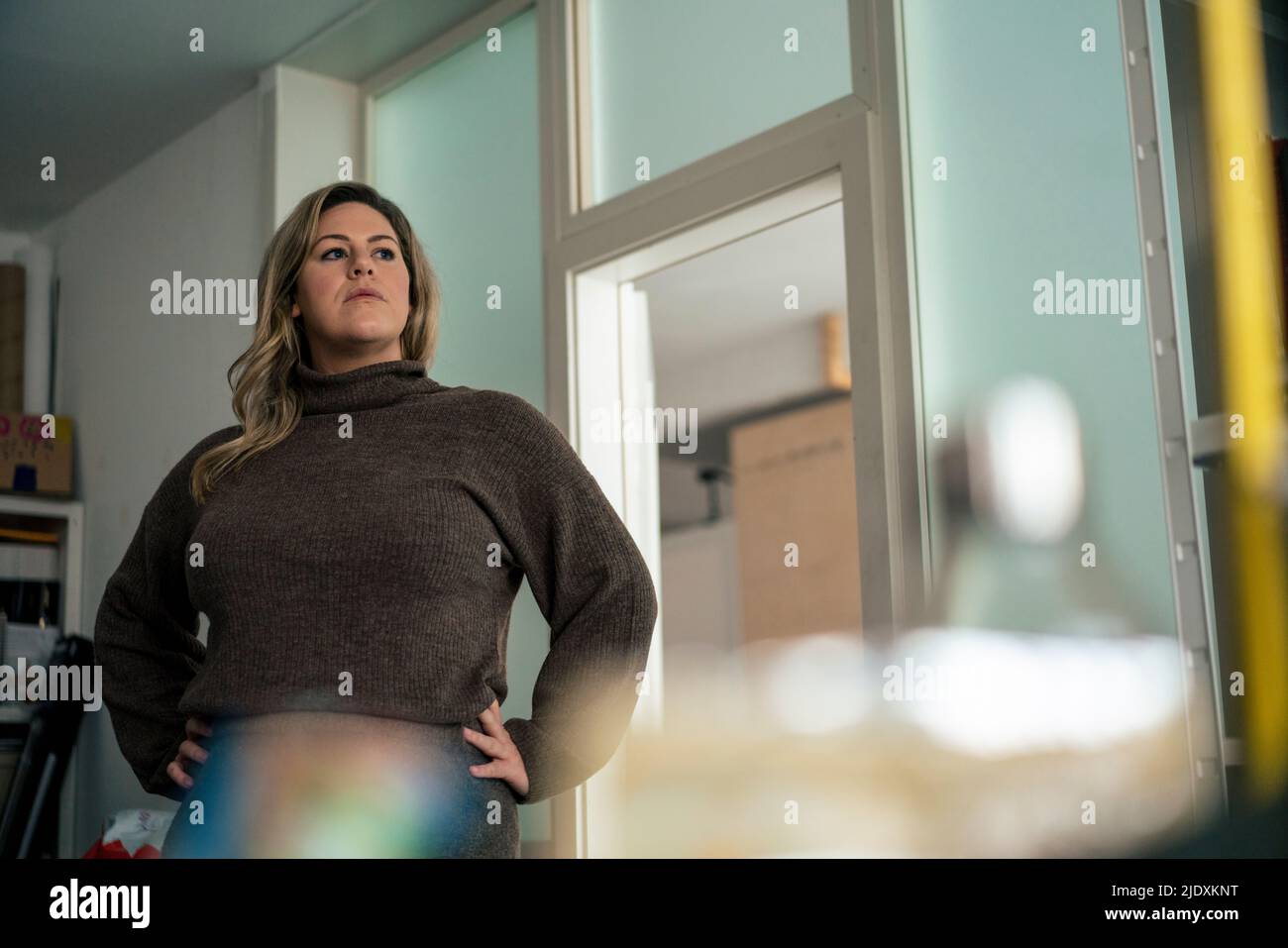 Confident plus size businesswoman with hands on hips in office Stock ...