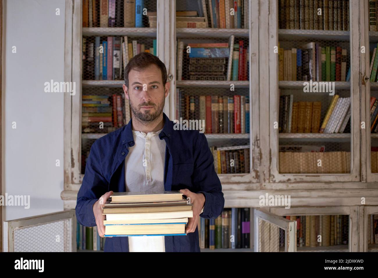 Man standing in front bookshelf hi-res stock photography and images - Alamy