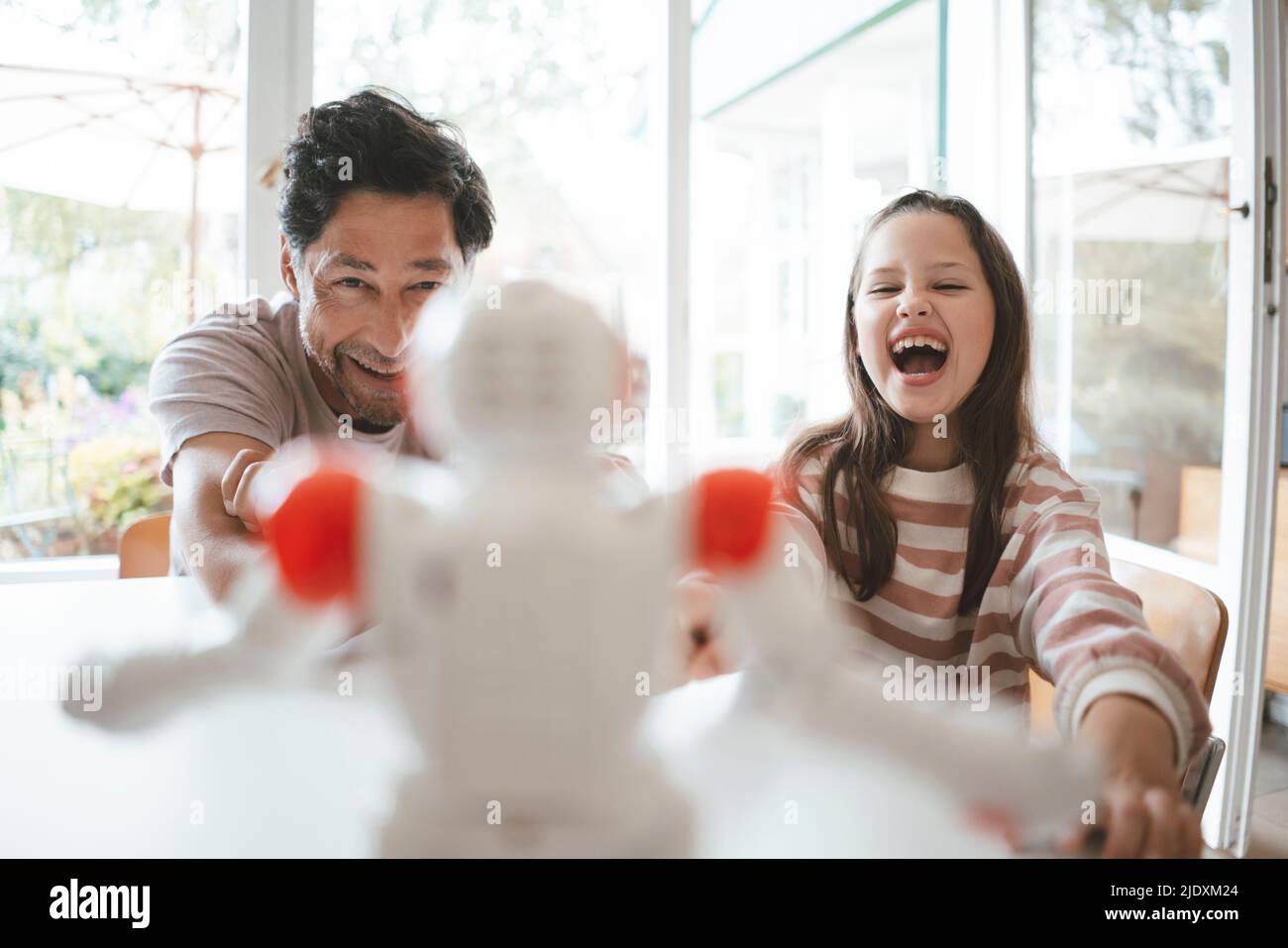 Happy father and daughter playing with toy robot at home Stock Photo ...