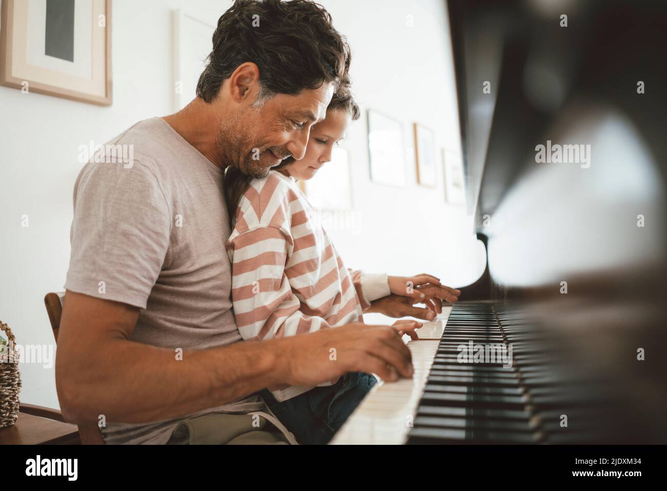 Happy father teaching piano to daughter at home Stock Photo - Alamy