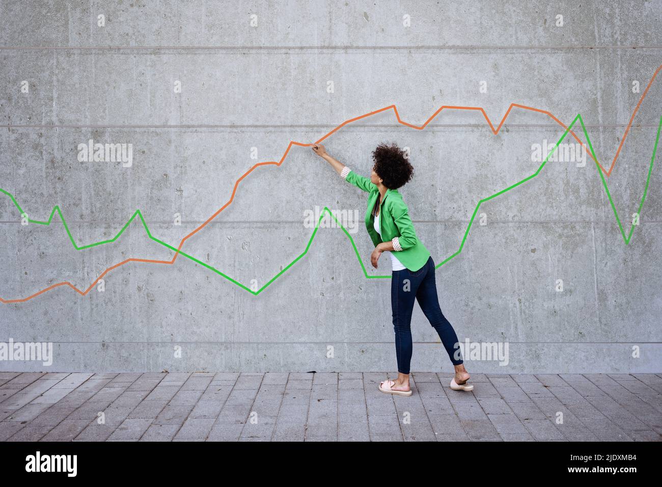 Young woman pointing at chart painted on wall Stock Photo - Alamy