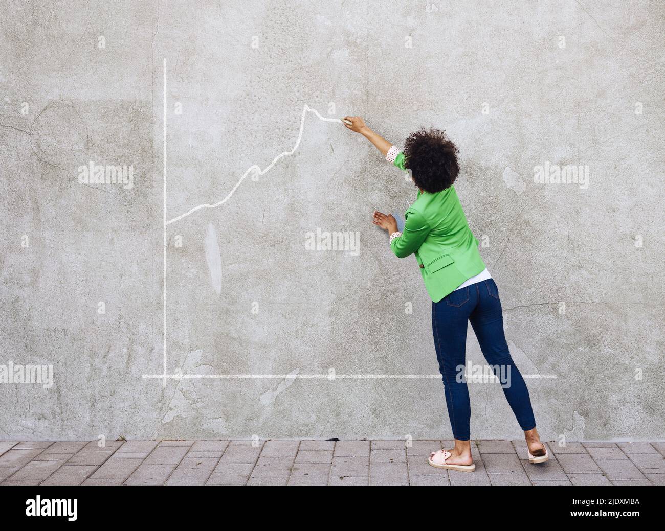 Young woman pointing at chart painted on wall Stock Photo - Alamy