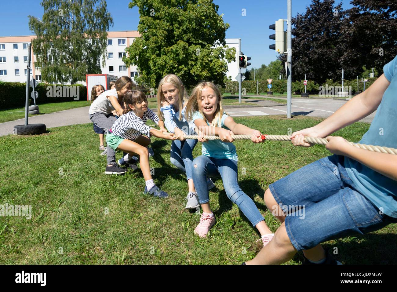 Children playing tug-of-war on sunny day Stock Photo - Alamy