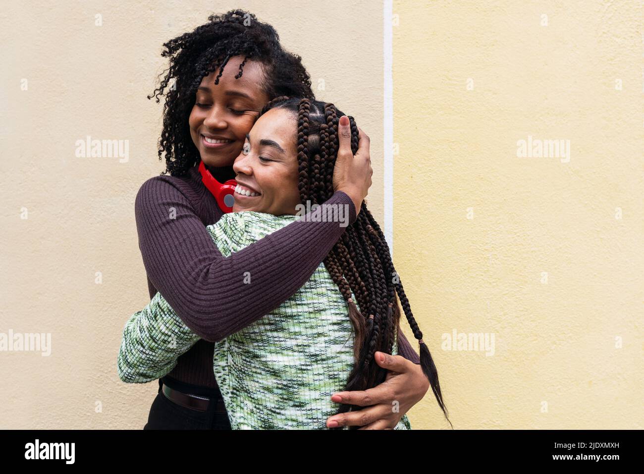 Two female friends hugging rear view hi-res stock photography and ...