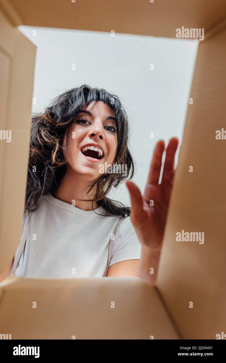 Happy woman with mouth open seen through cardboard box Stock Photo - Alamy