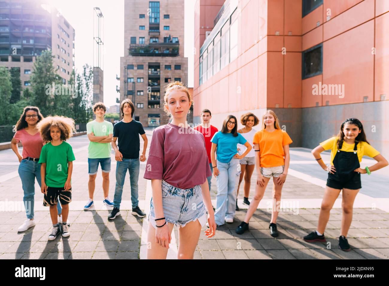 Smiling teenage girl standing in front of friends Stock Photo - Alamy