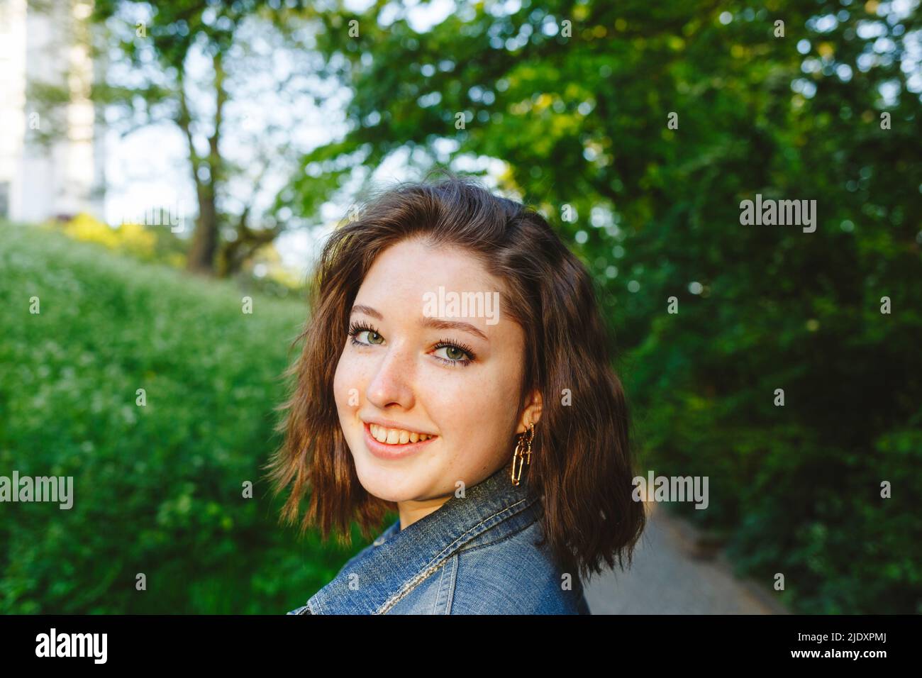 Smiling teenage girl wearing denim jacket in park Stock Photo - Alamy Smiling teenage girl wearing denim jacket in park Stock Photo - Alamy
