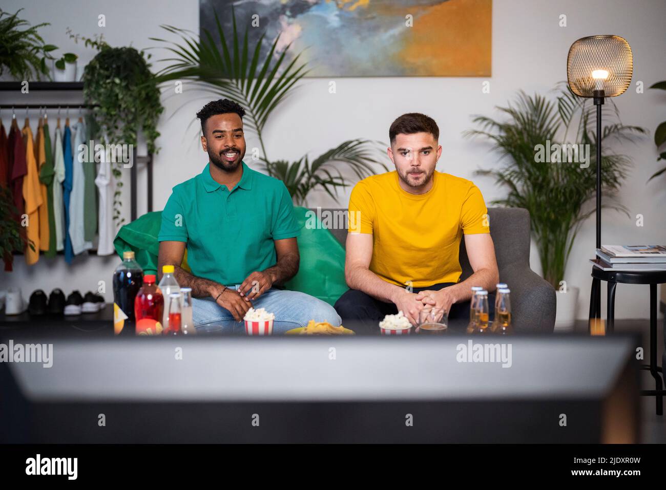 Two men sitting on sofa hi-res stock photography and images - Alamy