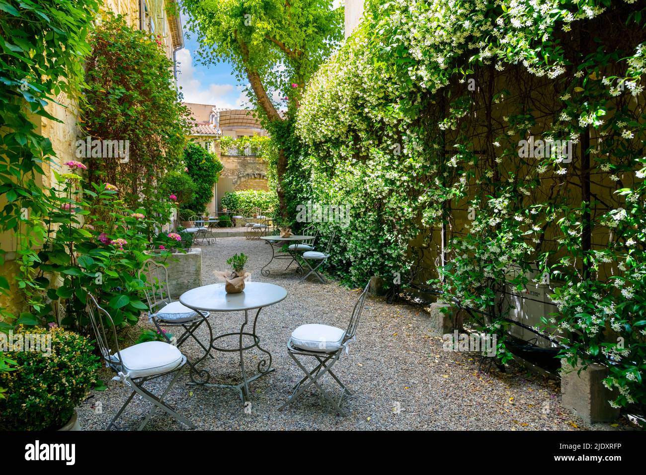 An empty, secluded cafe patio garden in the medieval village of Saint ...