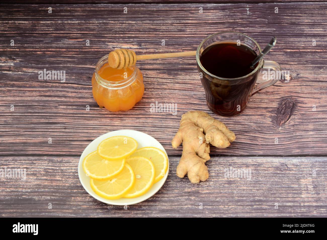 Alternative cold remedy, tea, honey, lemon and ginger root on a wooden ...