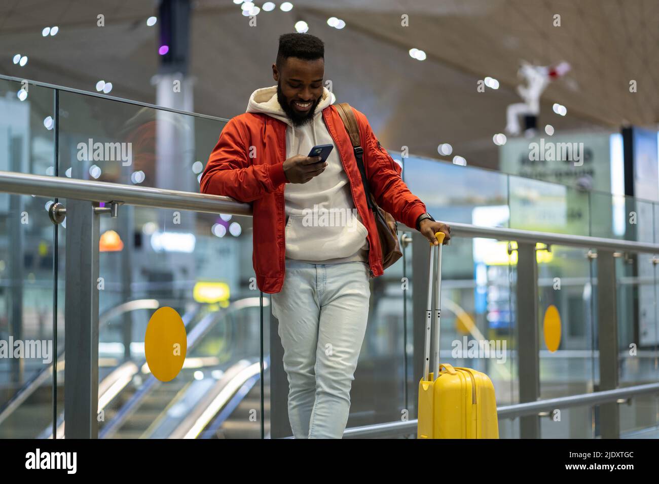 Smiling African American guy using smartphone, checking incoming ...